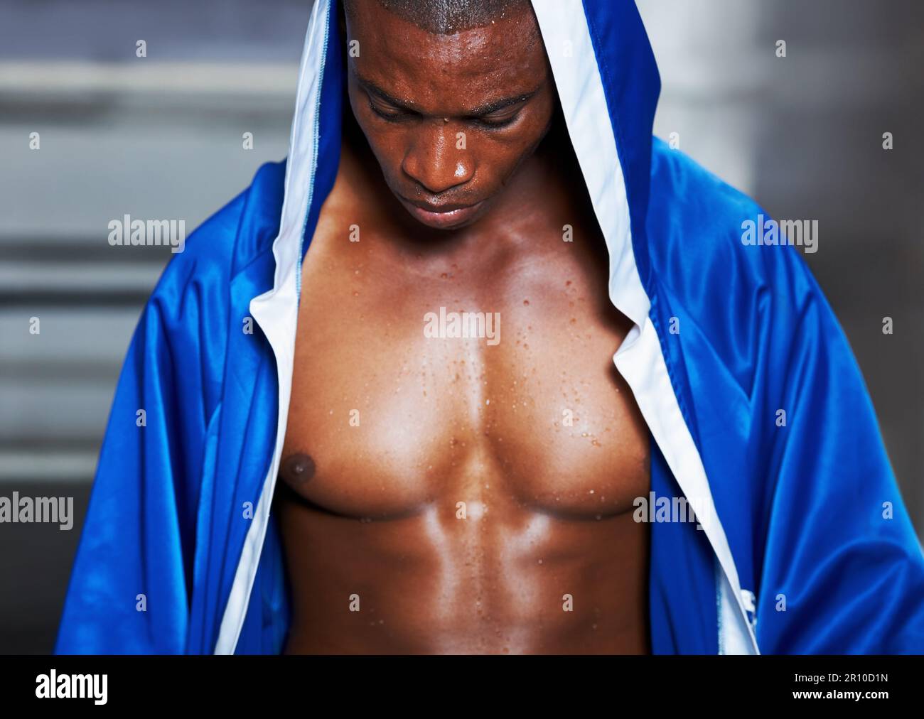 Ready to dominate. An african american boxer looking down in before a ...