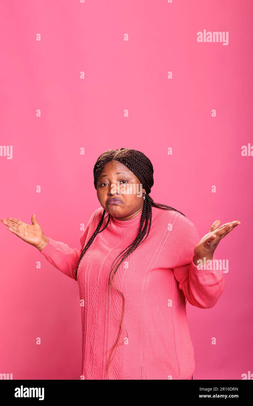 Doubtful indecisive woman raising shoulder and being confused about ...