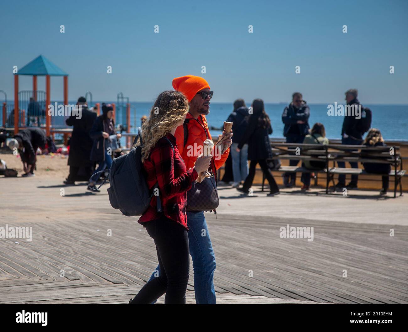 Couple Eating Ice Cream While Walking On The Boardwalk On Coney Island