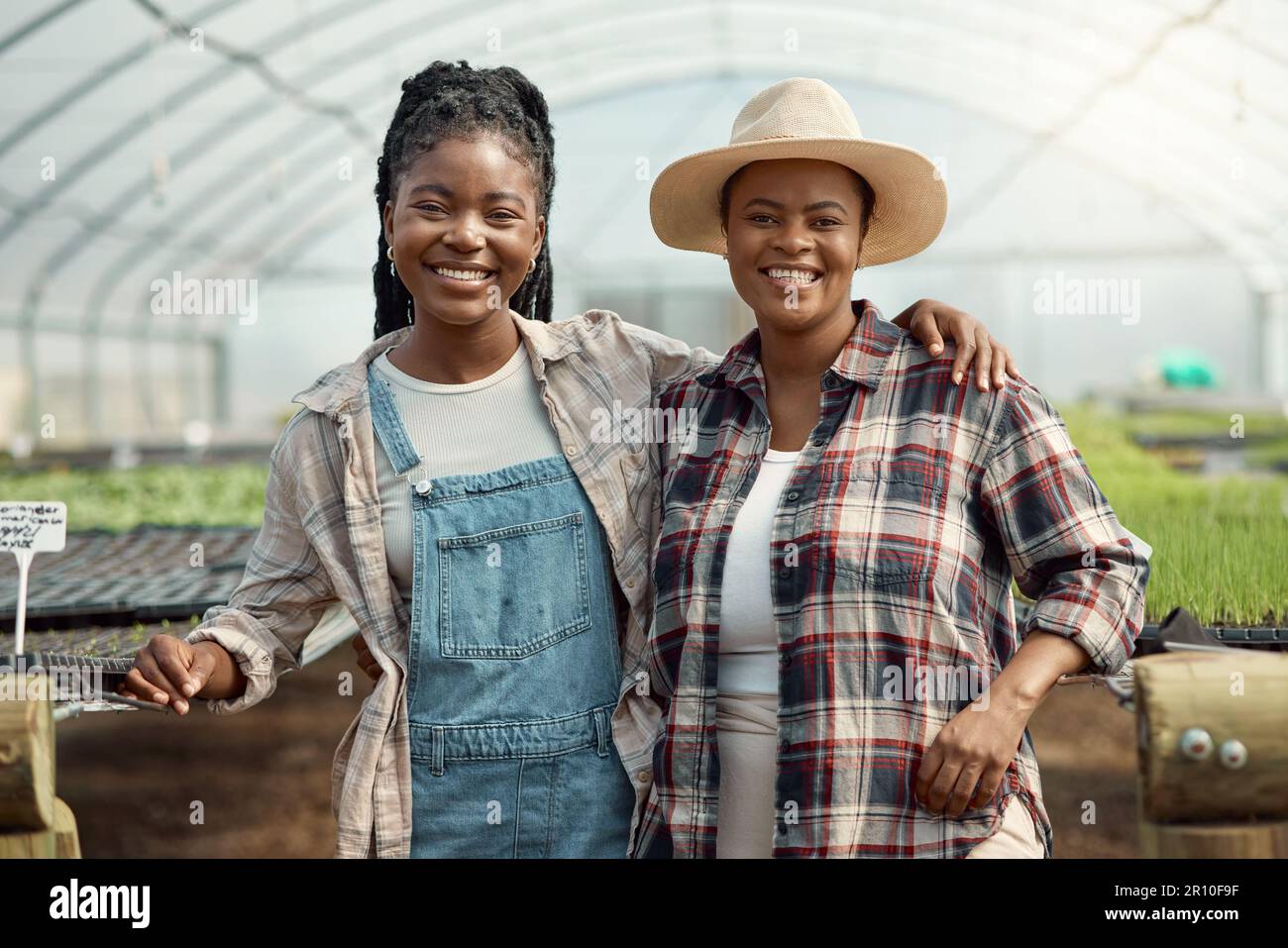 Portrait of two farm workers. Happy coworkers embracing in their garden ...