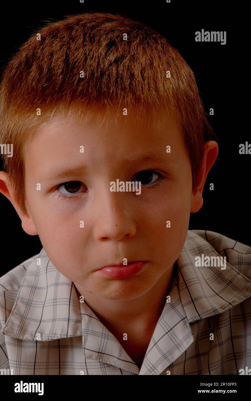 Low key portrait of a young boy isolated on black Stock Photo - Alamy