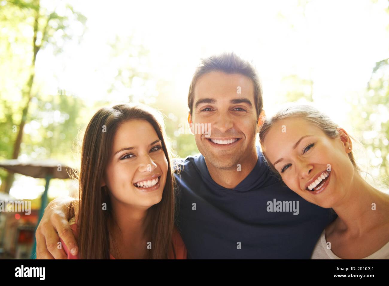 Good times. Three young friends embracing one another while enjoying a ...