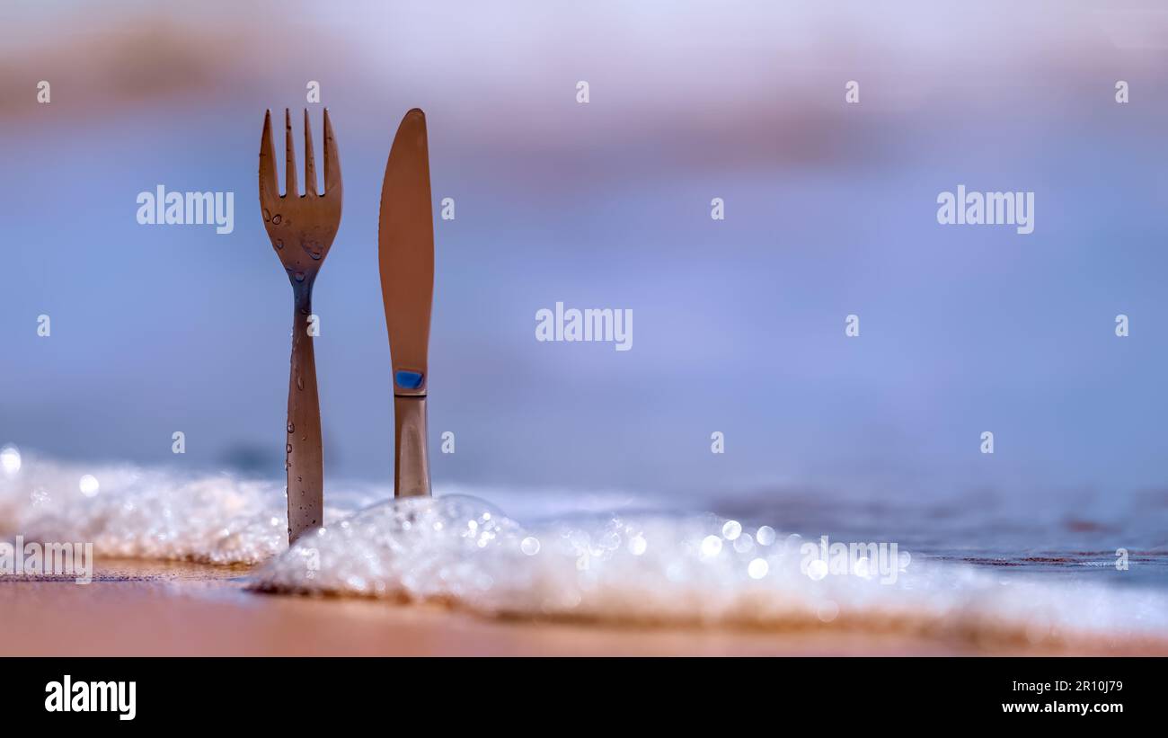 Knife and fork, the beach and the ocean Stock Photo - Alamy