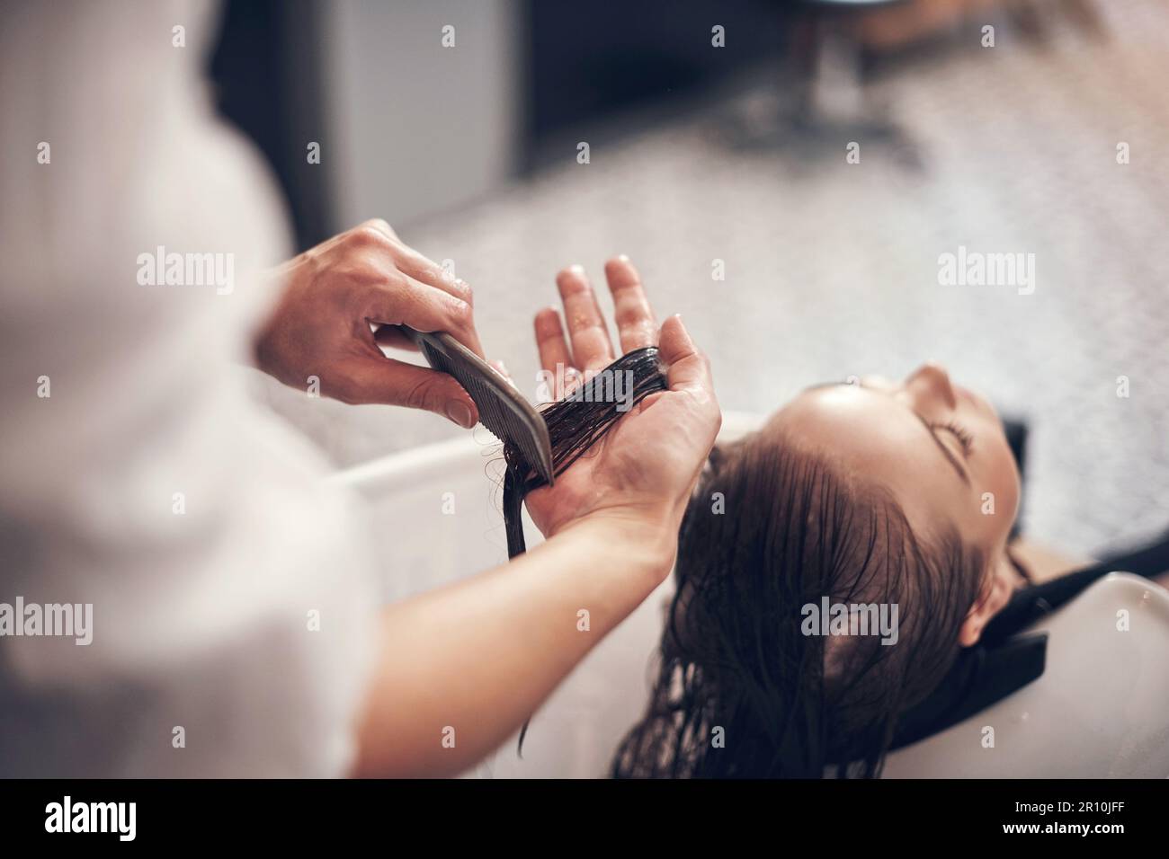 Let me comb the conditioner through. a stylist combing out a womans ...
