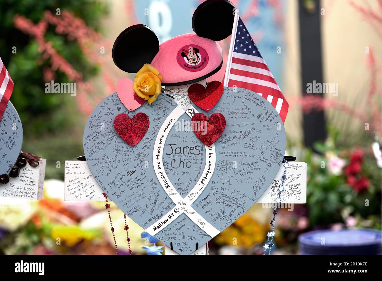 A cross with the name, James Cho, a victim of a mass shooting, stands ...