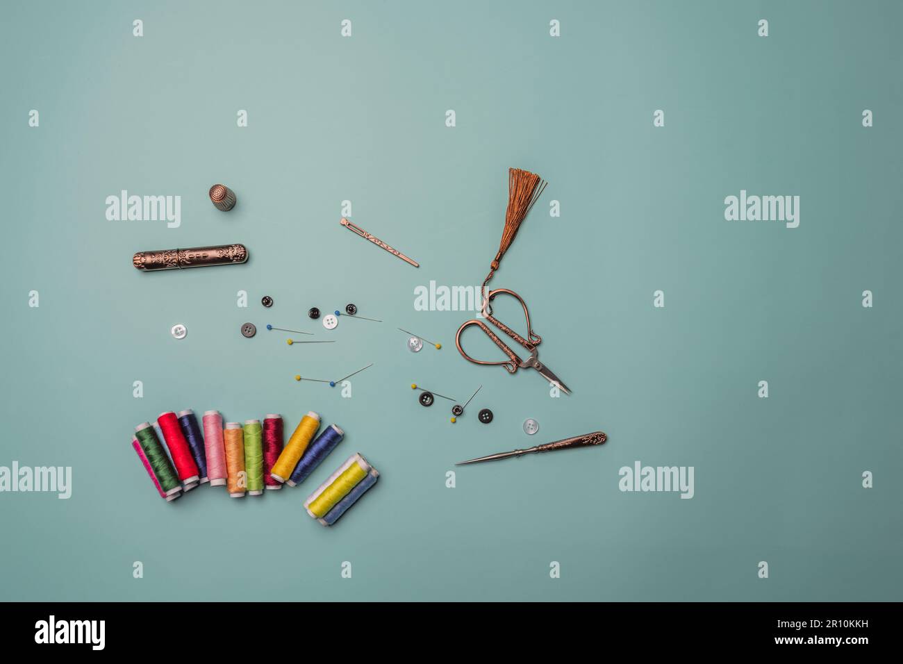 A few spools of seamstress thread with different colors together with ...