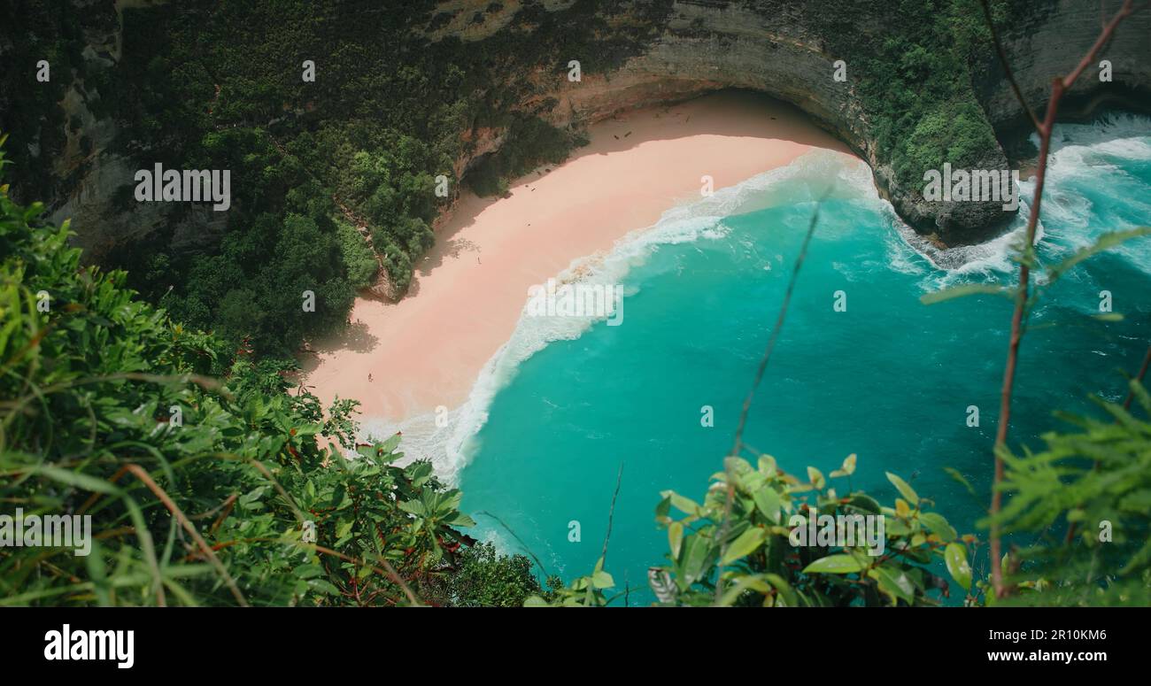 Tropical pink sandy Kelingking Beach with crystal clear ocean water on ...