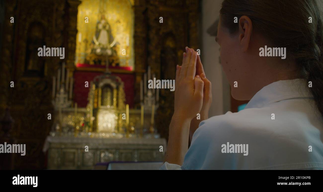 Devout christian woman prays sincerely in a church. Parishioner girl ...