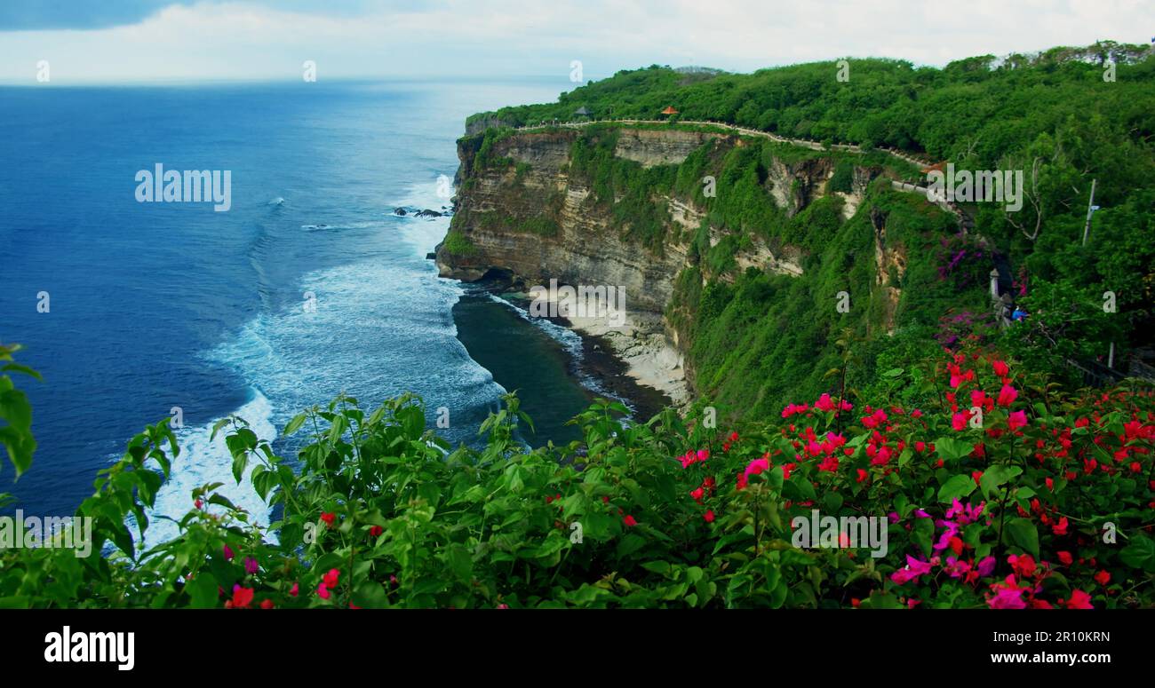 Pristine tropical green beach with Uluwatu Temple Pura Luhur Hindu on ...