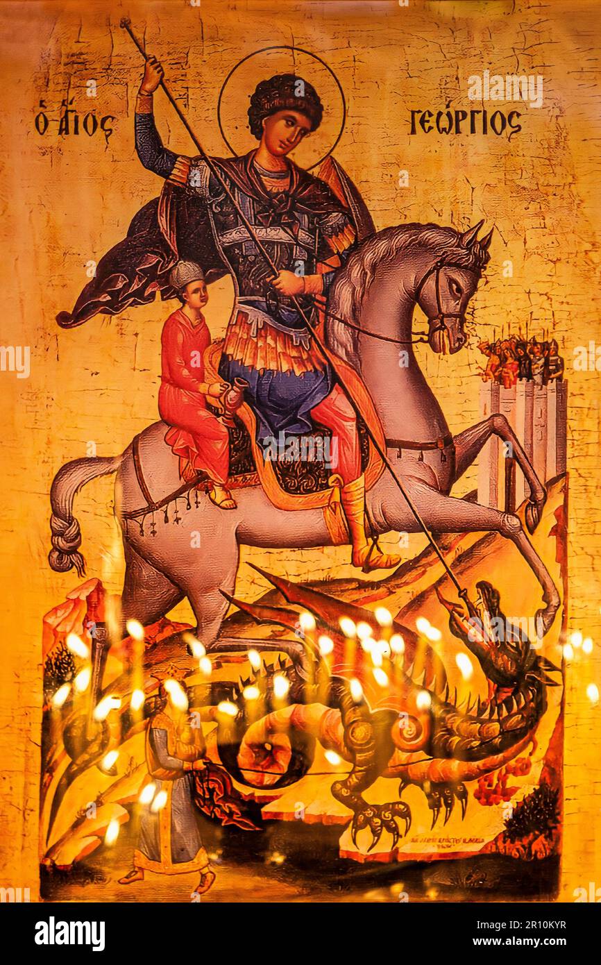 Icon of St George slaying the dragon, with reflection of votive candles ...