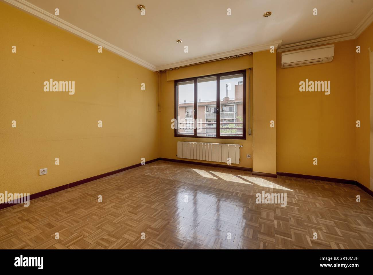Empty living room with oak parquet, white aluminum radiators under a ...