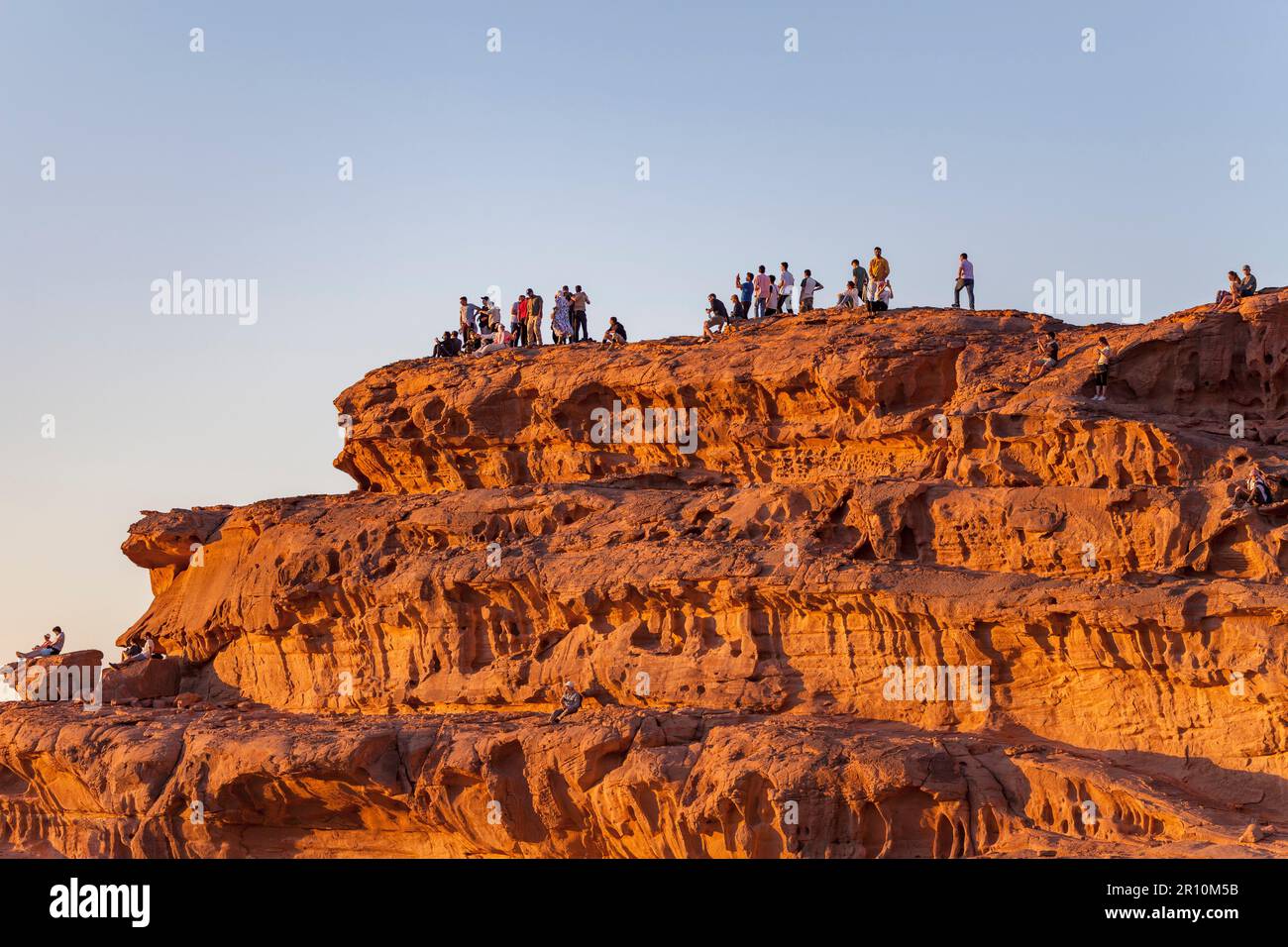 People watching the sunset from a sandstone cliff, Wadi Rum, Jordan ...