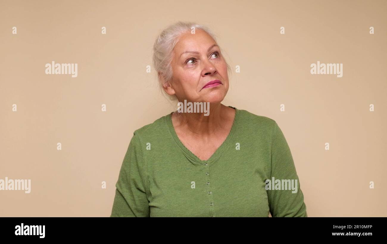 An elderly European woman looks with skepticism and distrust, not ...