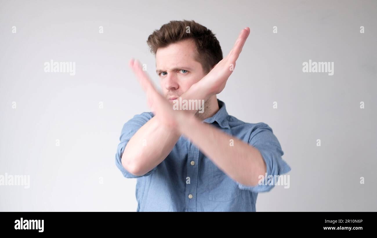 European young man shows a stop sign with his hands Stock Photo - Alamy