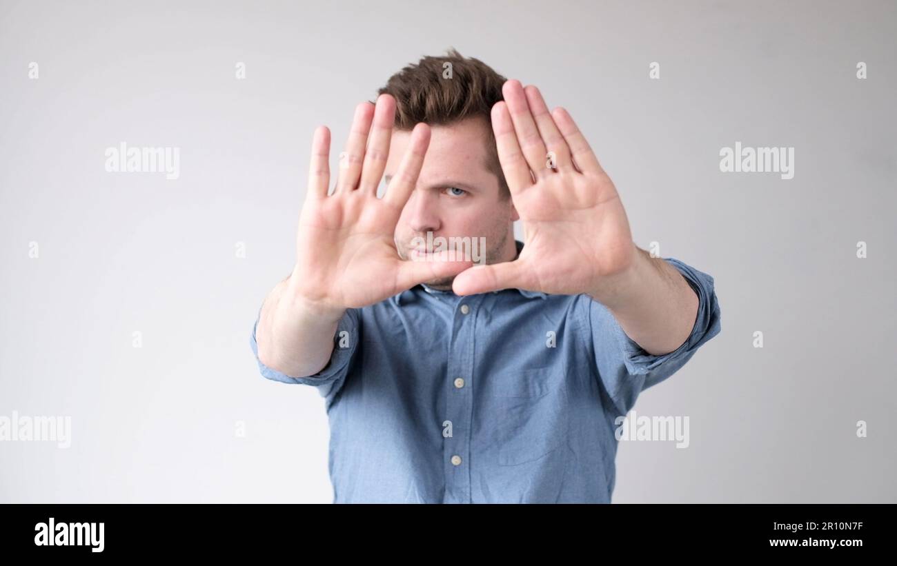 European young man shows a stop sign with his hands Stock Photo - Alamy