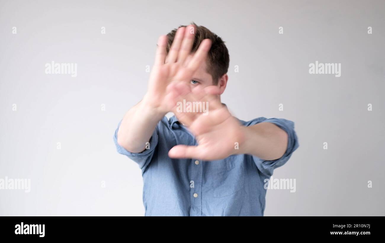European young man shows a stop sign with his hands Stock Photo - Alamy