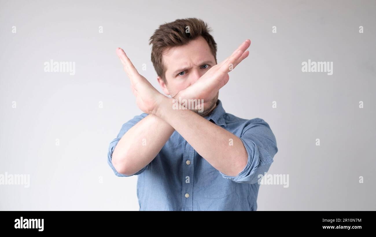European young man shows a stop sign with his hands Stock Photo - Alamy
