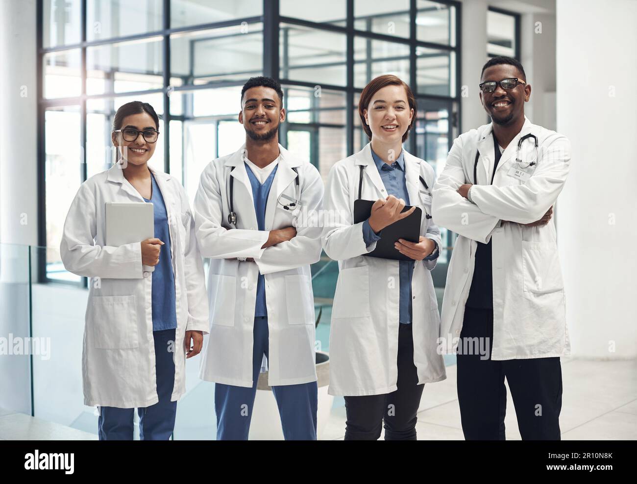Portrait of african male doctor standing in a row with medical team hi ...