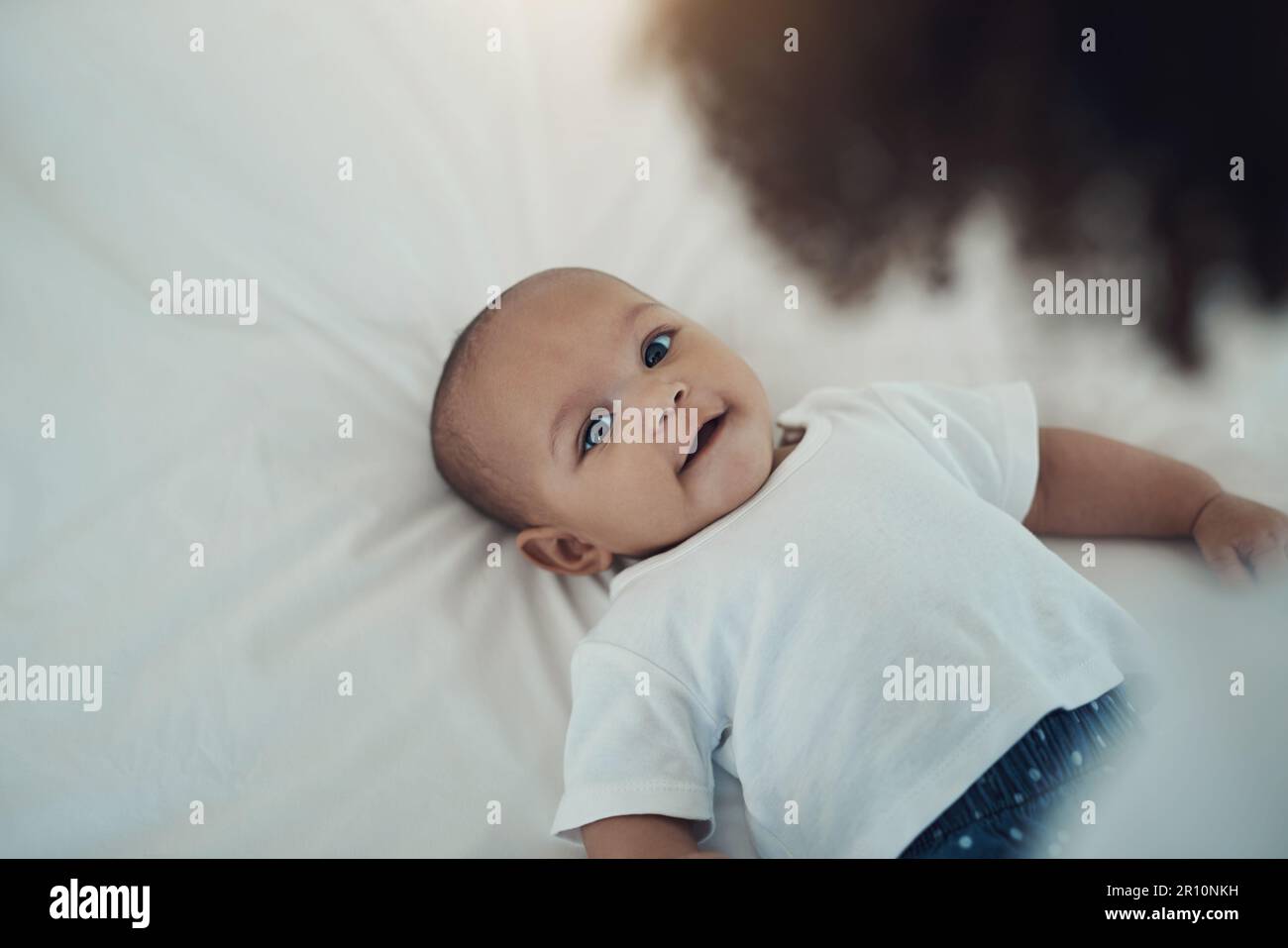 Love is the language of a mom. an adorable baby girl gazing at her ...