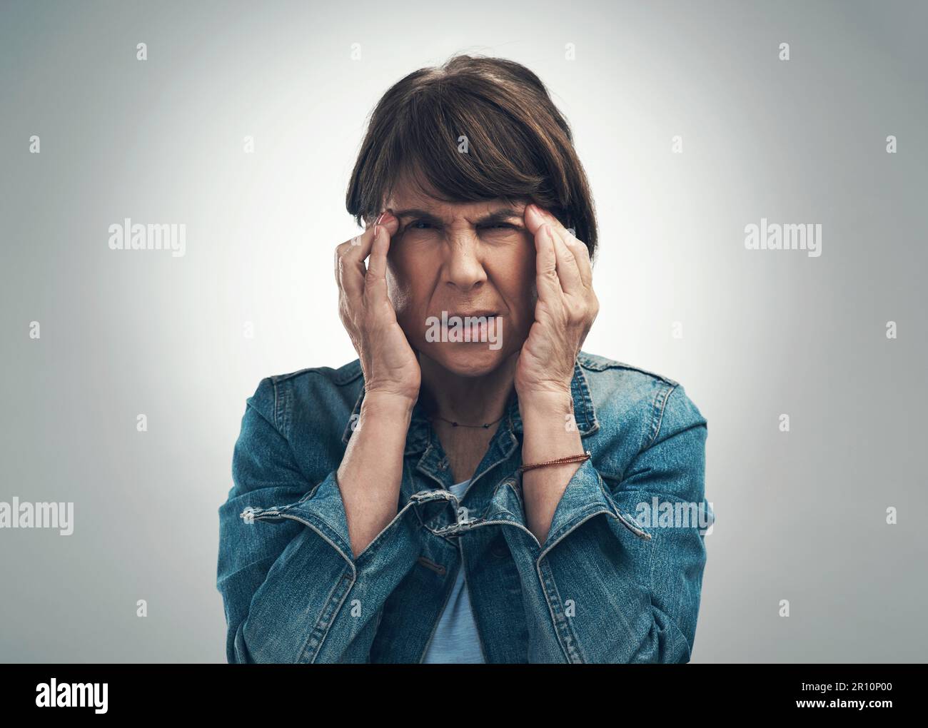 My heads spinning round and round. Studio portrait of a senior woman ...