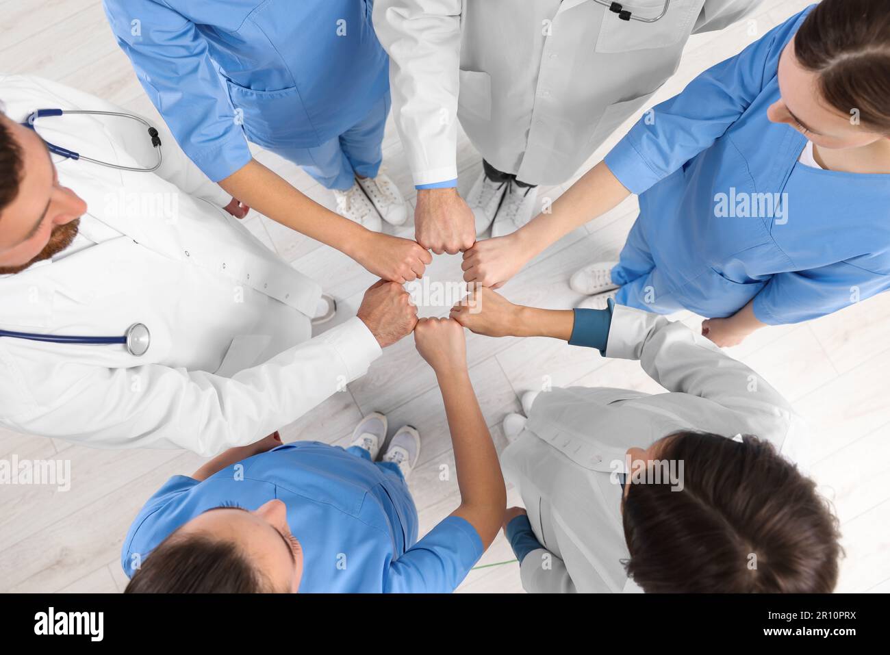 Team of medical doctors putting hands together indoors, above view ...
