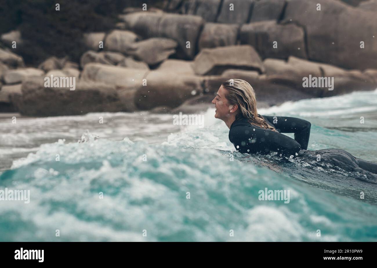 Surfing is a magical experience. a young woman out surfing at the beach ...