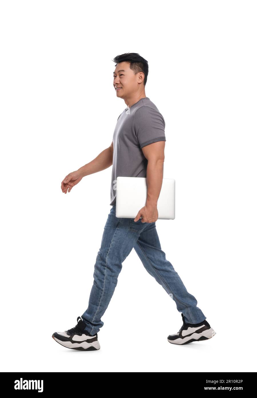 Man with laptop walking on white background Stock Photo - Alamy