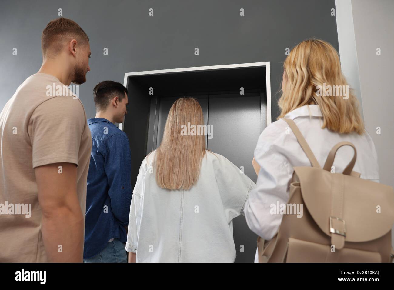 Group of people waiting for elevator in modern building Stock Photo - Alamy