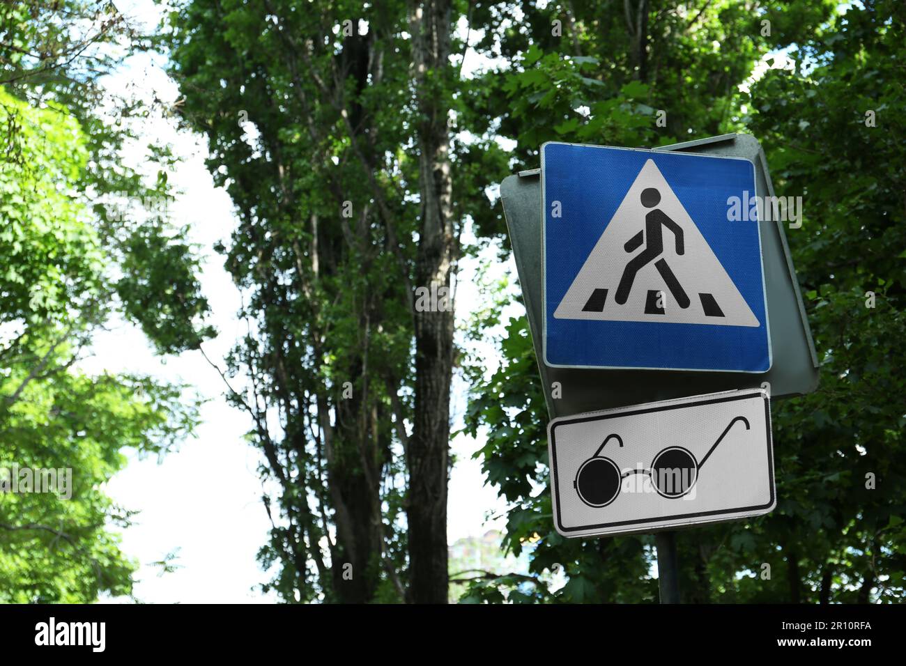 Different traffic signs near trees outdoors, space for text Stock Photo ...