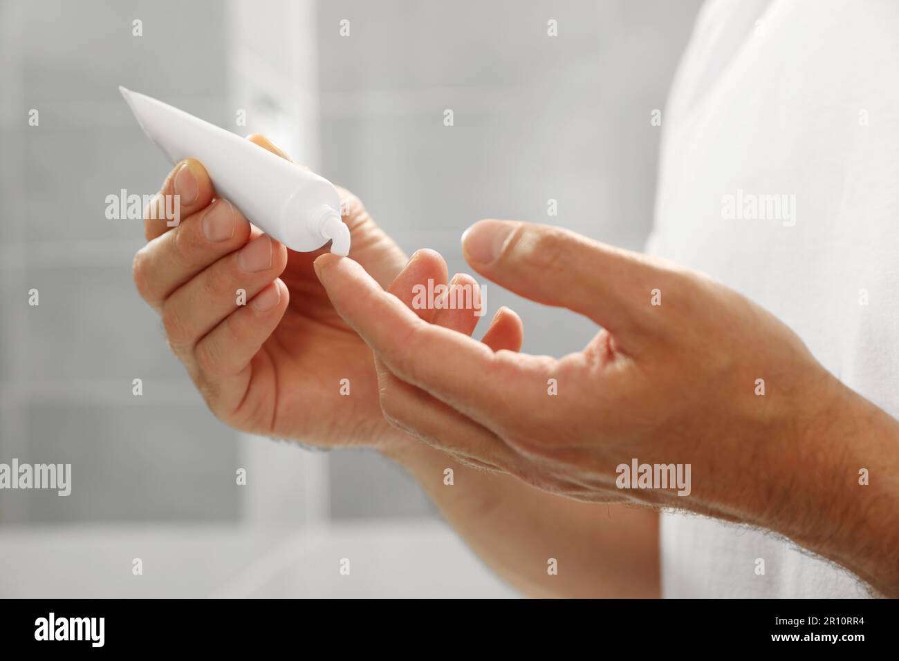 Handsome man applying cream in bathroom, closeup Stock Photo - Alamy