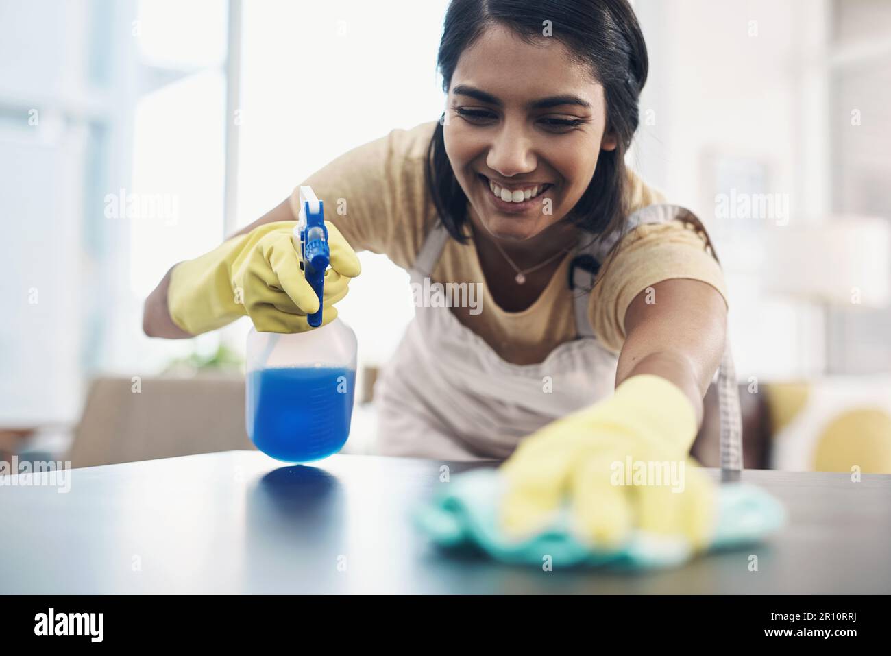 As clean as clean should be. a young woman disinfecting a table at home ...