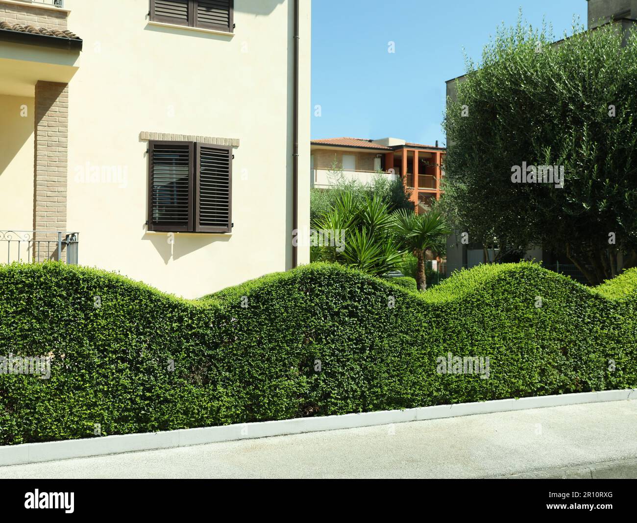 Residential building with beautiful green hedge on sunny day Stock ...