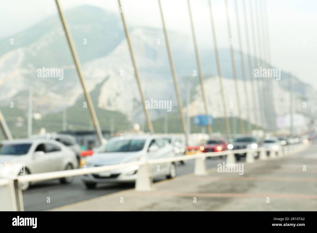 Blurred view of modern bridge and cars near mountain Stock Photo - Alamy