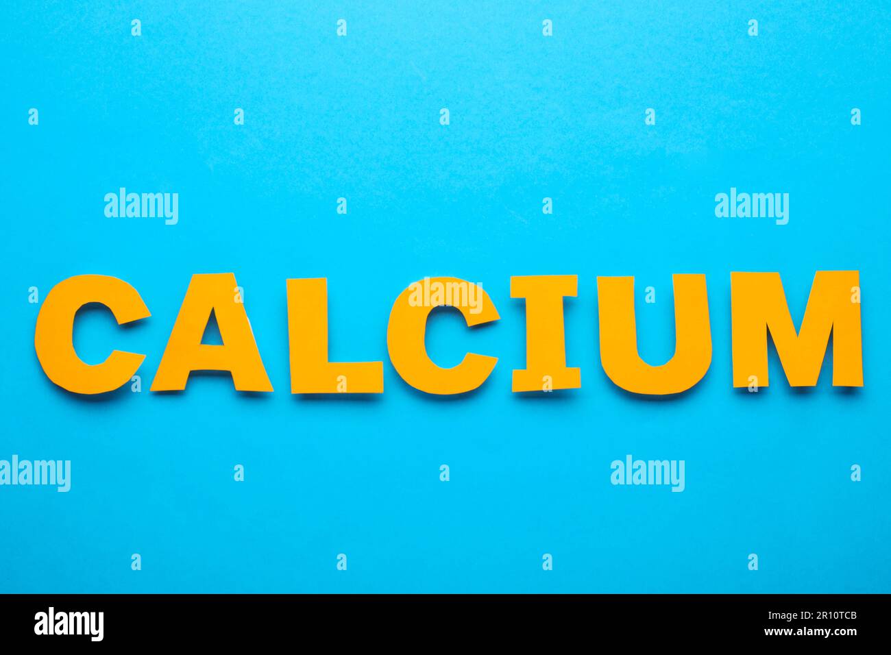 Word Calcium made of orange letters on light blue background, flat lay ...