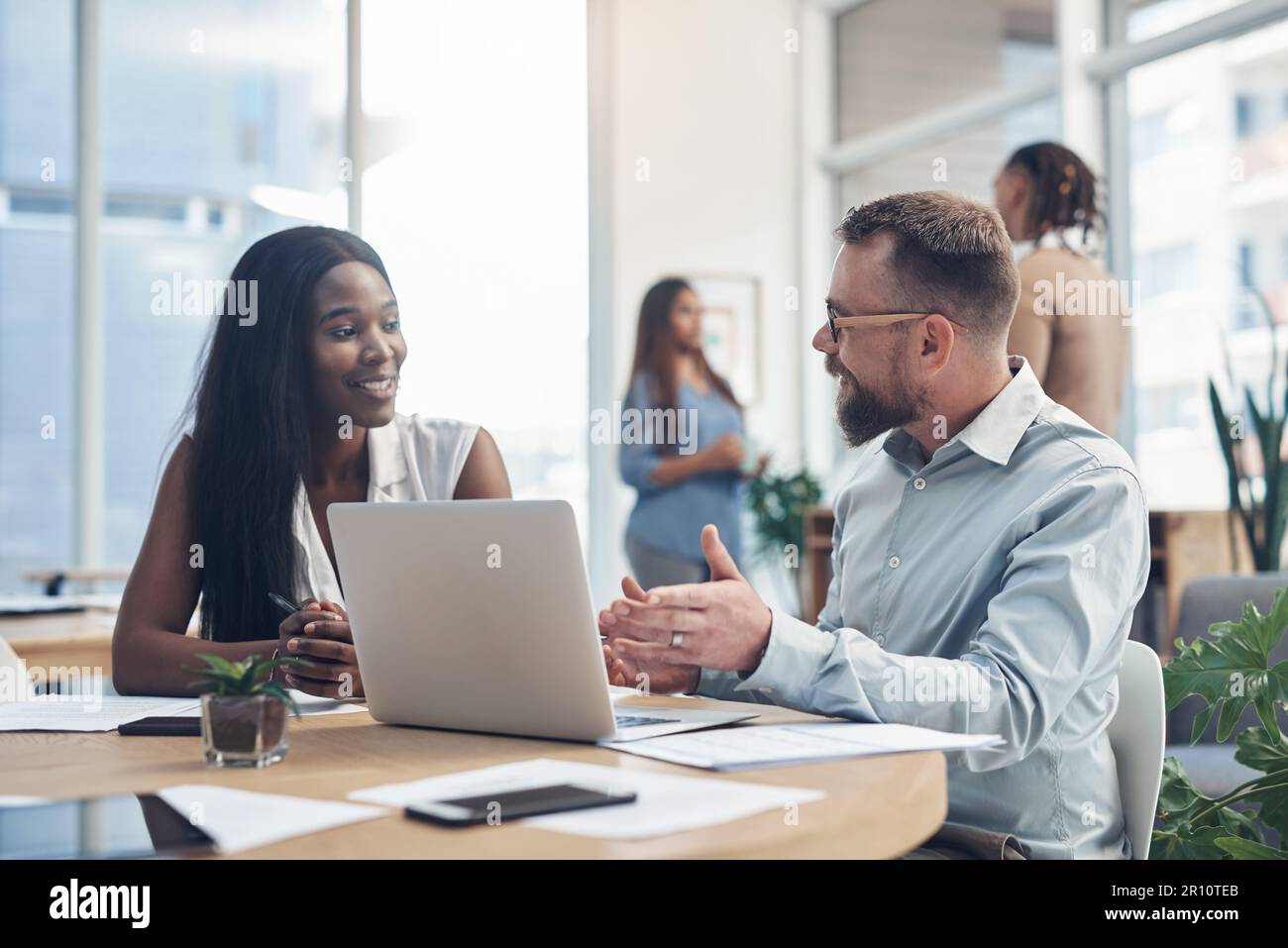 Communication is vital for success. two young businesspeople sitting ...