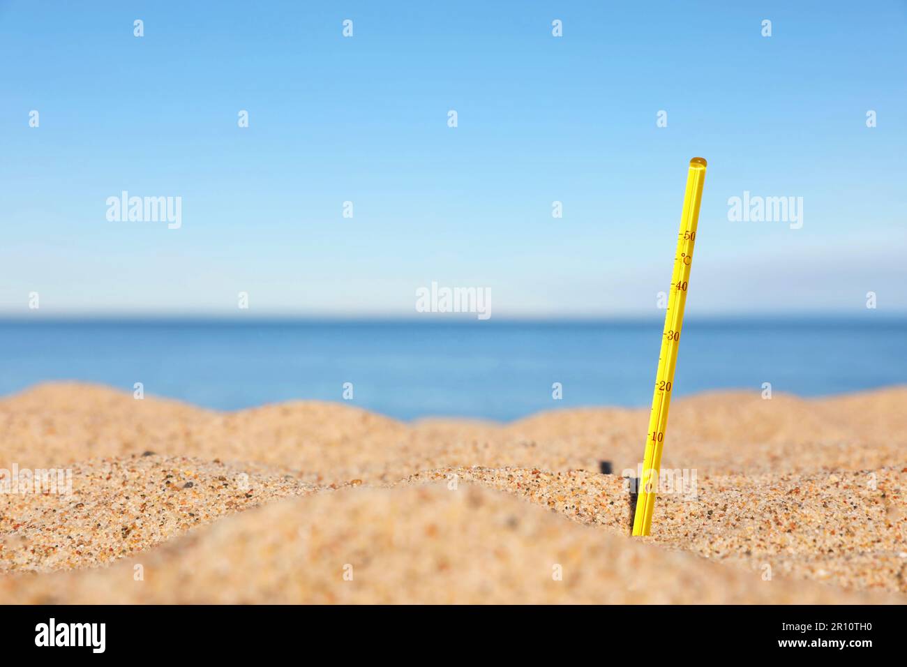 Yellow weather thermometer in sand near sea, space for text Stock Photo ...