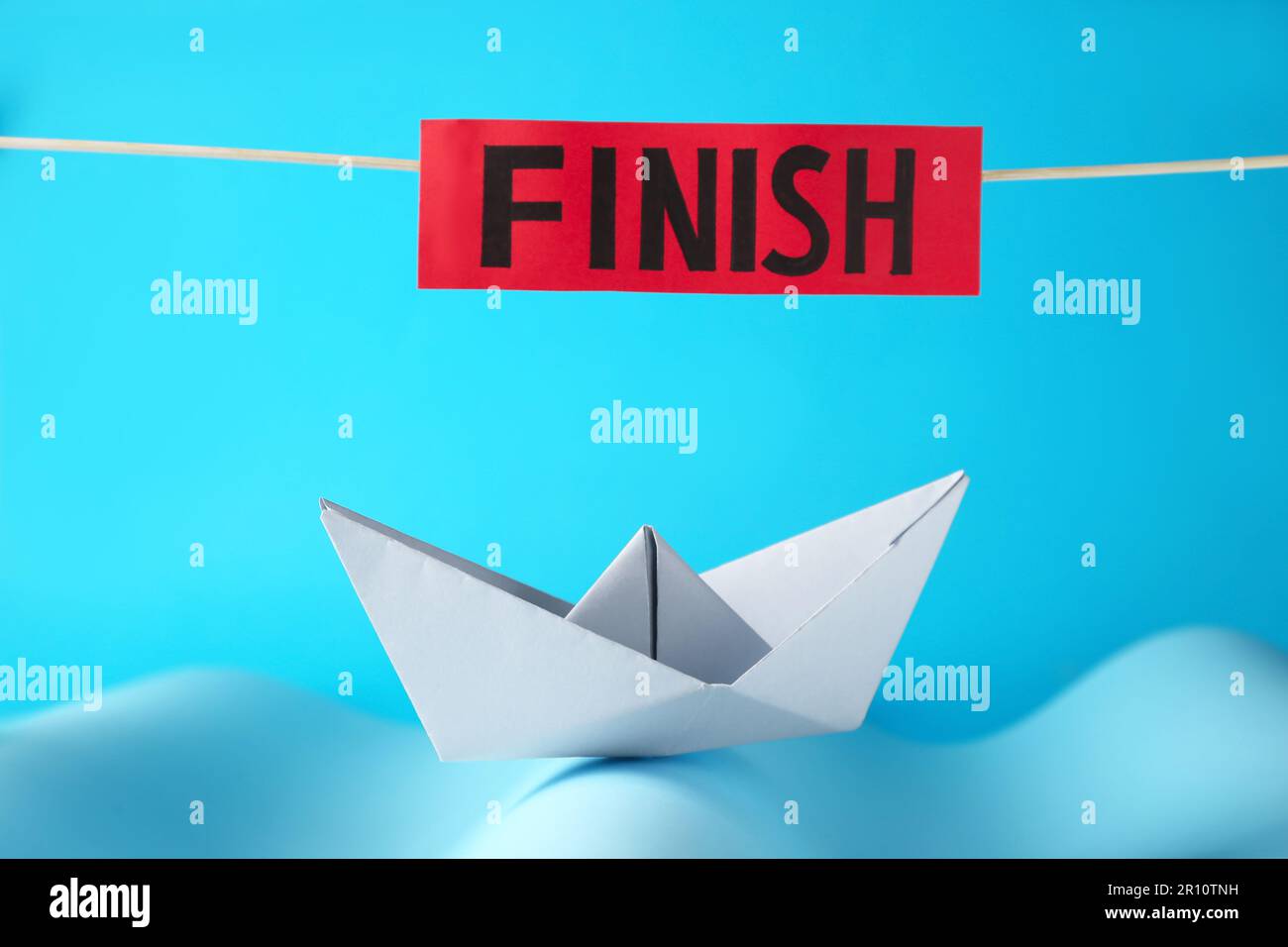 Competition concept. Paper boat among waves and red sign with word ...