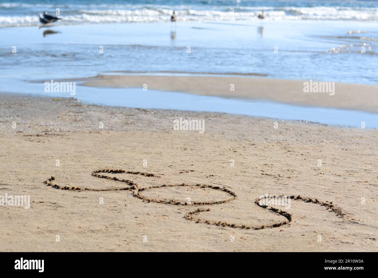 Sos message written on sand hi-res stock photography and images - Alamy
