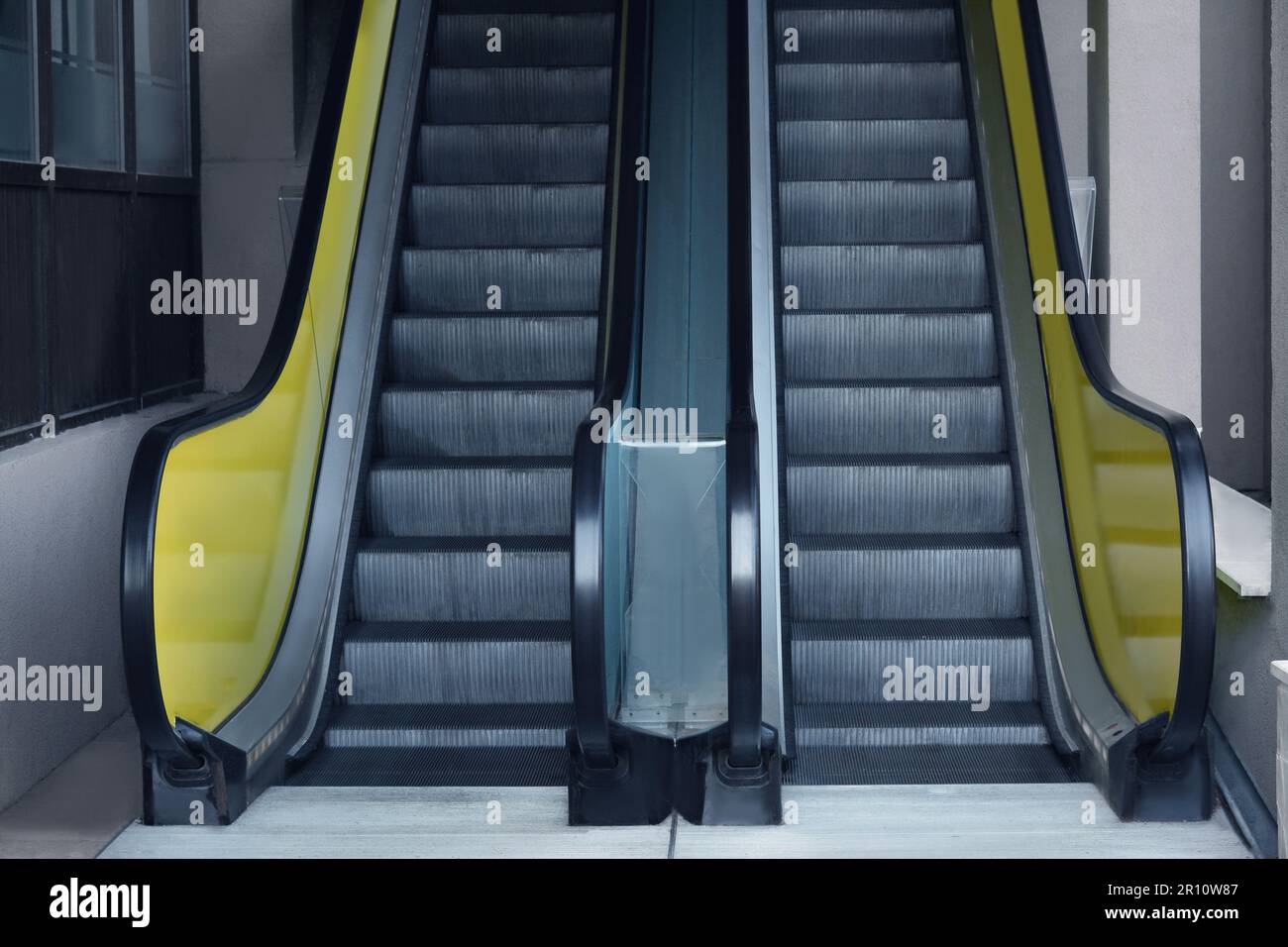 View on empty parallel escalators with yellow balustrades Stock Photo ...