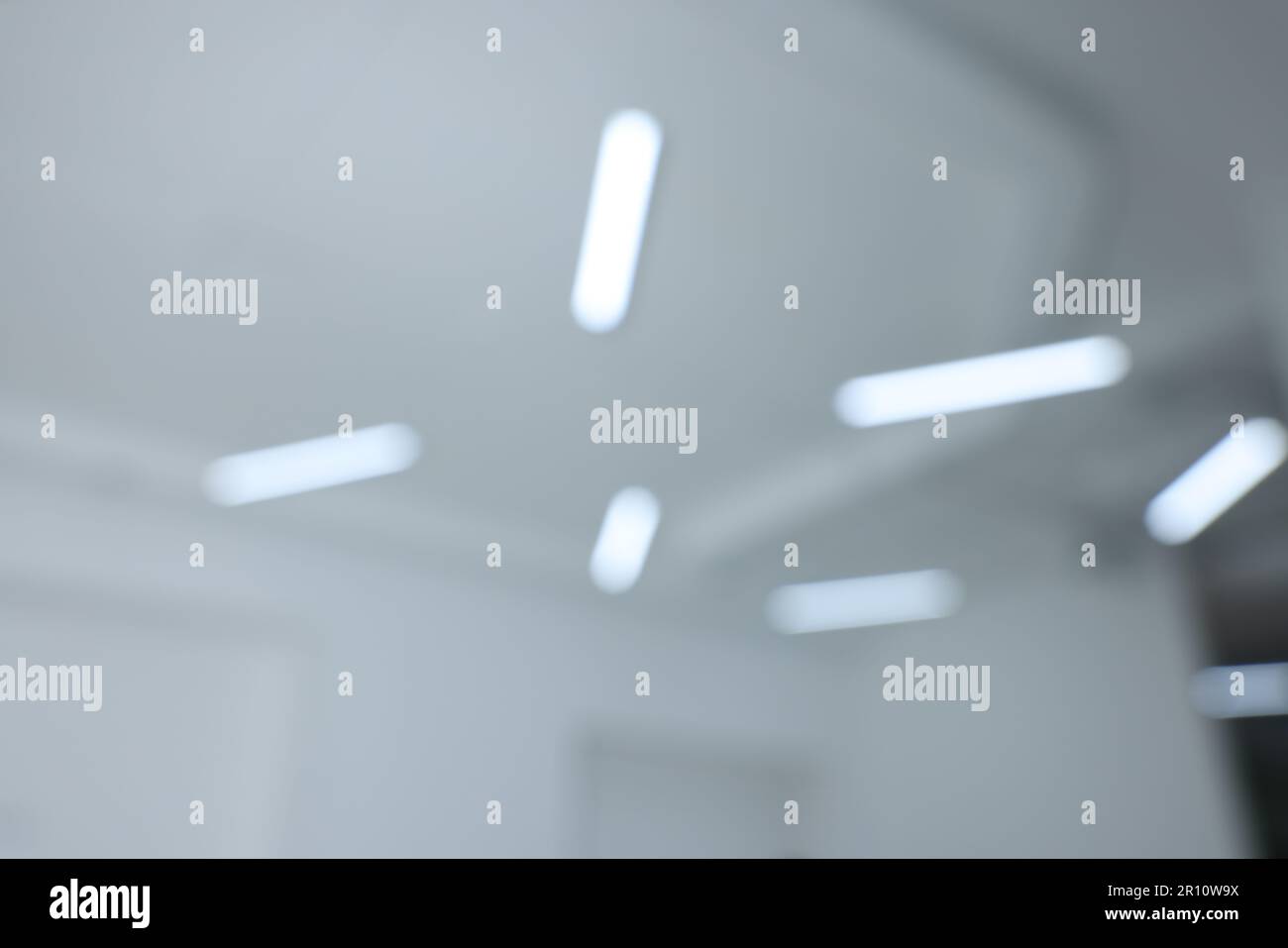 Blurred view of white ceiling with modern lights Stock Photo - Alamy