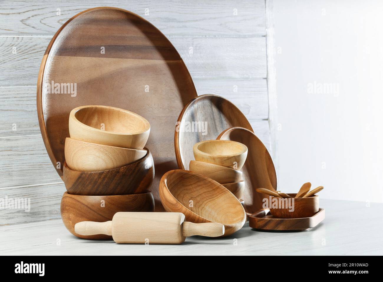 Set of clean wooden dishware and utensils on table Stock Photo - Alamy