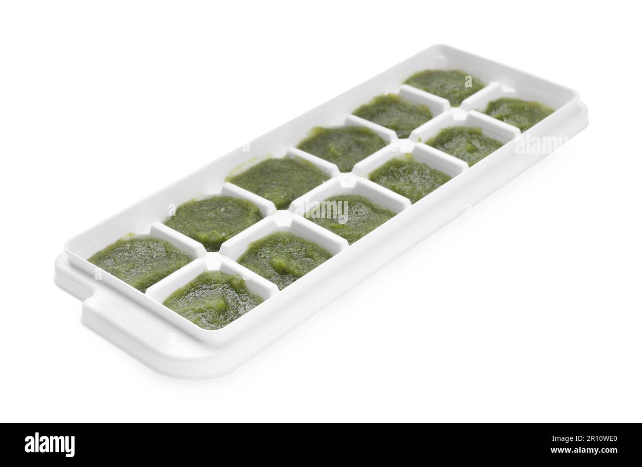 Broccoli puree in ice cube tray isolated on white. Ready for freezing ...