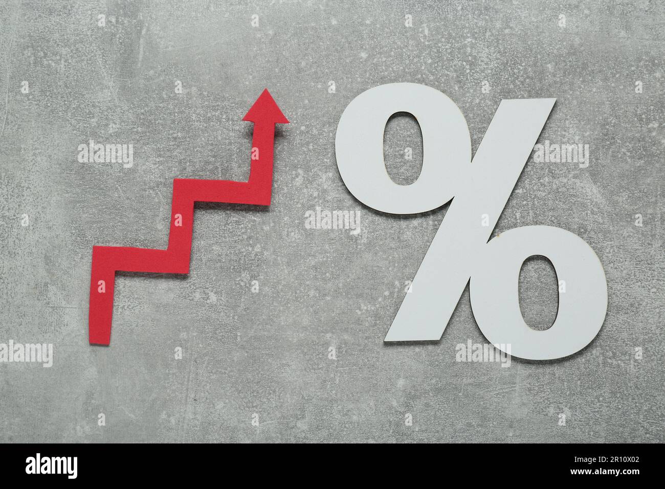 Up arrow and percent symbol on light grey table, top view. Profit ...