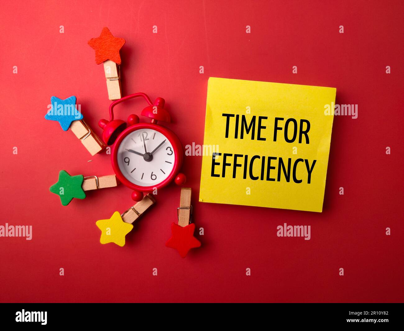 Alarm clock and wooden clips with word TIME FOR EFFICIENCY on a red ...