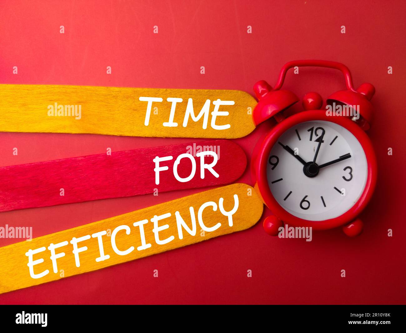 Clock and wooden stick with word TIME FOR EFFICIENCY on a red ...