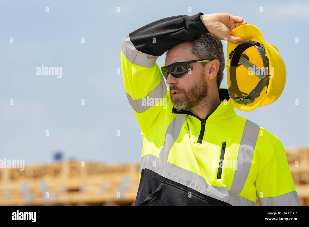 Tired, overworked builder near american wood frame house construction ...