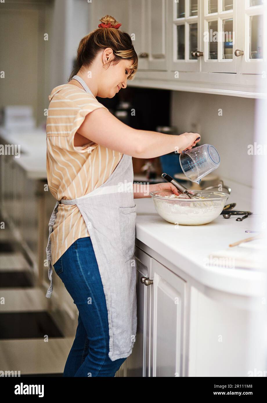 Baking is a form of therapy. an unrecognizable woman adding milk to her ...