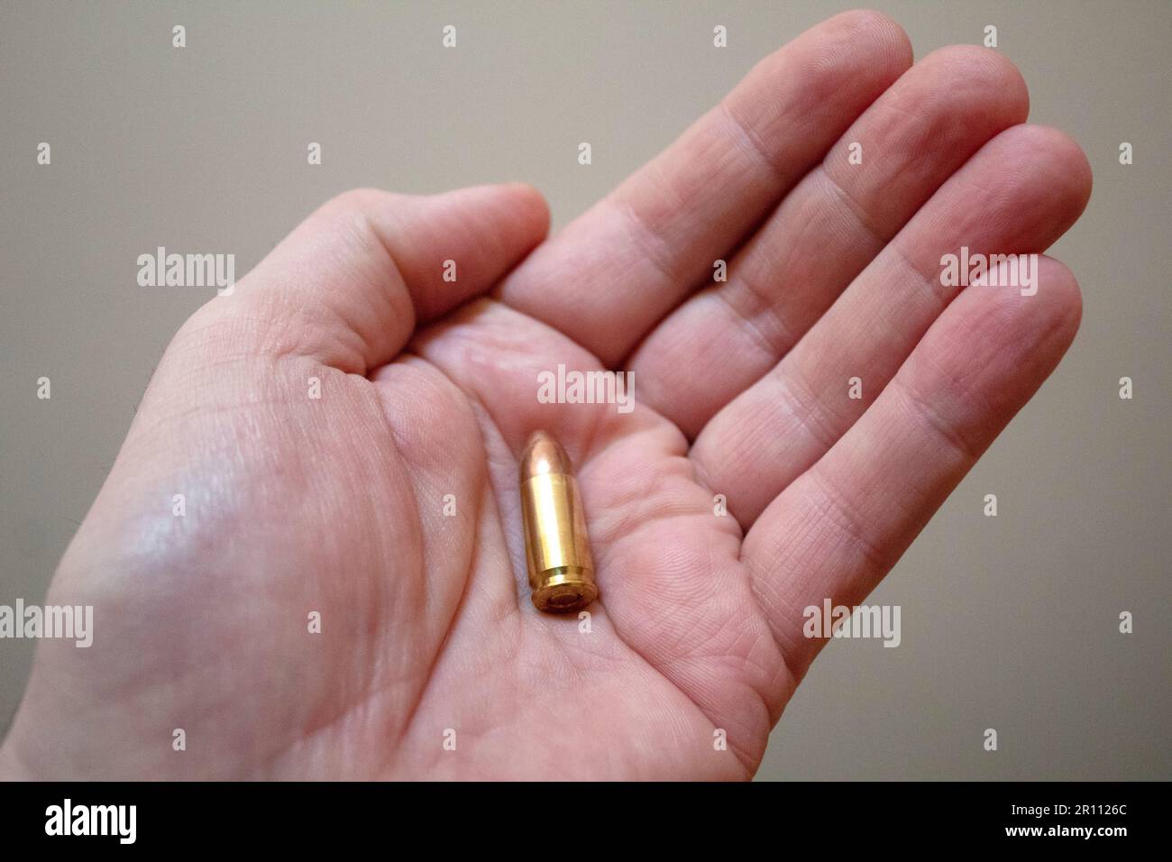 Bullet in hand Stock Photo - Alamy