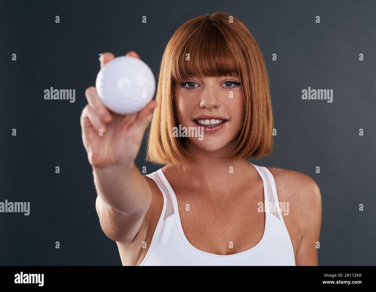Lets see who plays better. a sporty young woman posing with a ball ...
