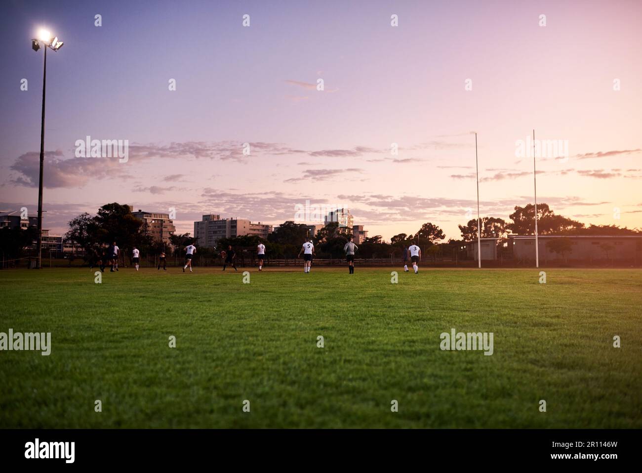 Rugby and a sunrise. Full length shot of a diverse group of sportsmen ...